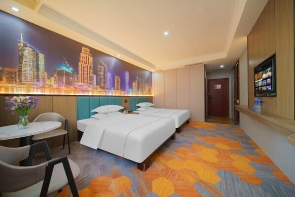 Quarto de hotel com mural da paisagem urbana, uma cama, uma mesa com cadeiras e uma televisão na parede.