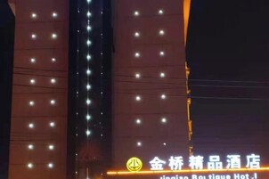 Fachada de edifício com luzes uniformemente espaçadas e um letreiro com caracteres chineses.