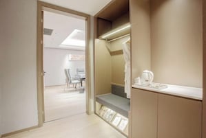 Casa de banho moderna com lavatório, porta-toalhas e máquina de café no balcão.