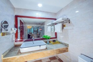 Uma casa de banho moderna com um espelho grande, lavatório e zona de duche.