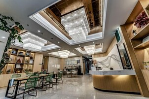 Um saguão de hotel moderno com balcão de recepção, área de estar e iluminação decorativa.
