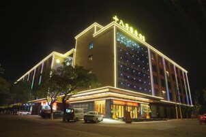 Hotel com placa visível, vários andares e fachada bem iluminada.