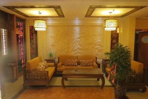 Sala de estar em estilo tradicional, com um sofá, uma mesa de centro e arte decorativa nas paredes.