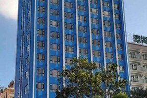 Um edifício alto, de cor azul, com várias janelas.