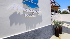 Placa de hotel com logotipo de palmeira e o nome 'Maragaoj Pousada'.