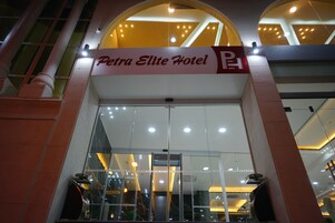 A entrada do Hotel Petra Elite, com uma placa grande acima da porta.