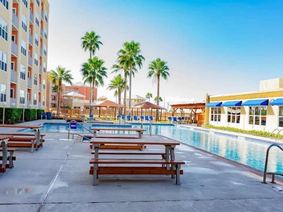 Uma área de piscina de hotel, com espreguiçadeiras e piscina.