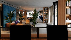 Um lobby moderno com áreas de estar, uma planta grande e uma estante de livros.