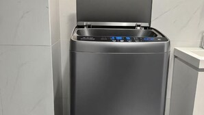Uma cozinha compacta e moderna, equipada com lava-louças embutida, micro-ondas e pia.