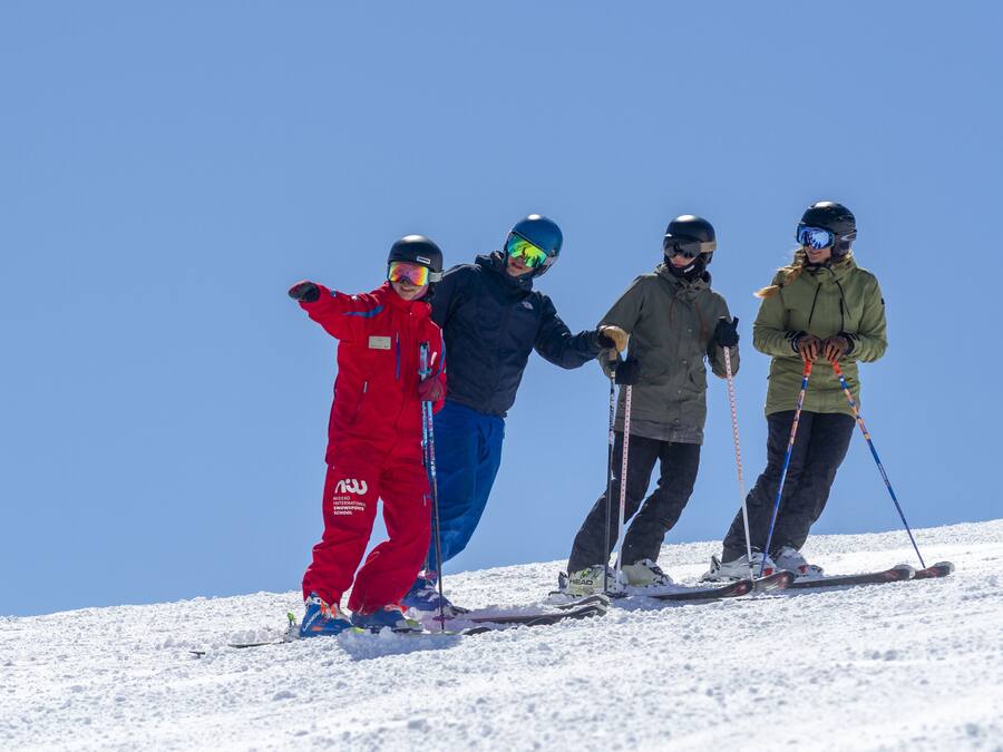 Um grupo de pessoas esquiando numa encosta coberta de neve.