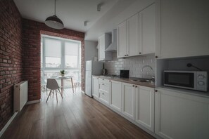 Um frigorífico/congelador grande, um micro-ondas, uma placa de cozinha 