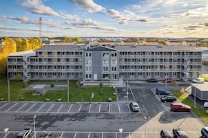 Um hotel com vários andares, estacionamento, área de estar externa e vista para os arredores.