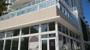 Um edifício moderno de vários andares com fachada curva, janelas amplas e entrada de vidro.