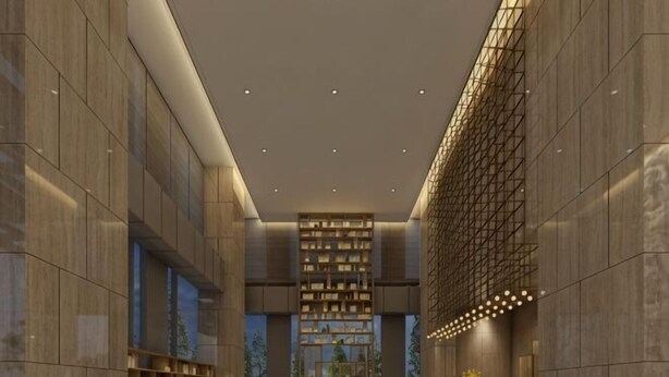 Um interior moderno com uma escadaria central, estantes de livros e uma parede estampada.