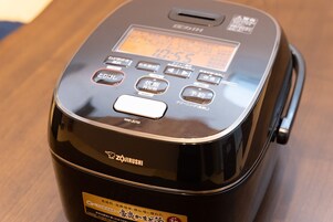 Uma panela de arroz elétrica preta com visor digital e vários botões, incluindo um botão 'Relaid'.