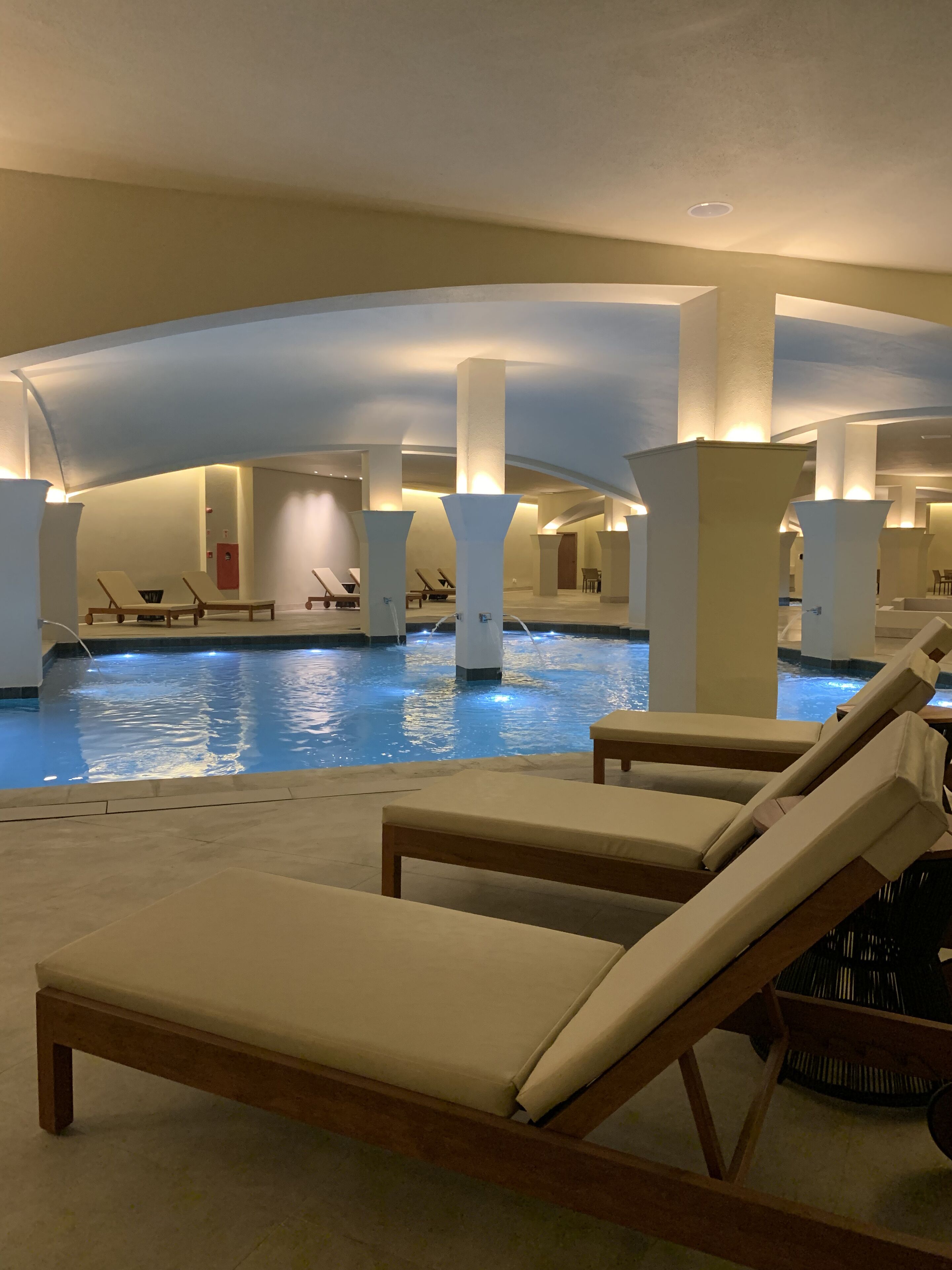 Uma área de piscina com espreguiçadeiras e um elemento aquático.