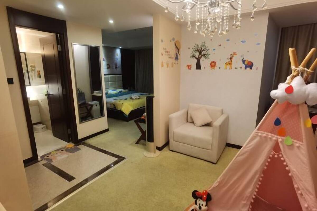 Quarto de criança com cama, cadeira, tenda e espelho.