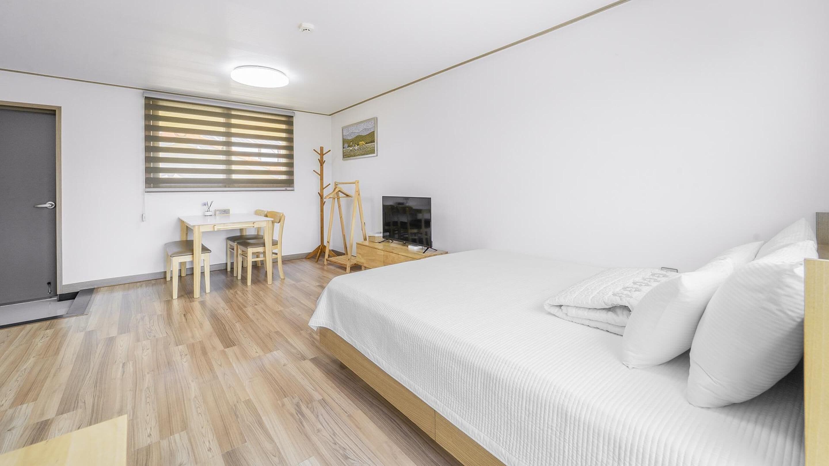 Quarto com cama, escrivaninha e cadeira.