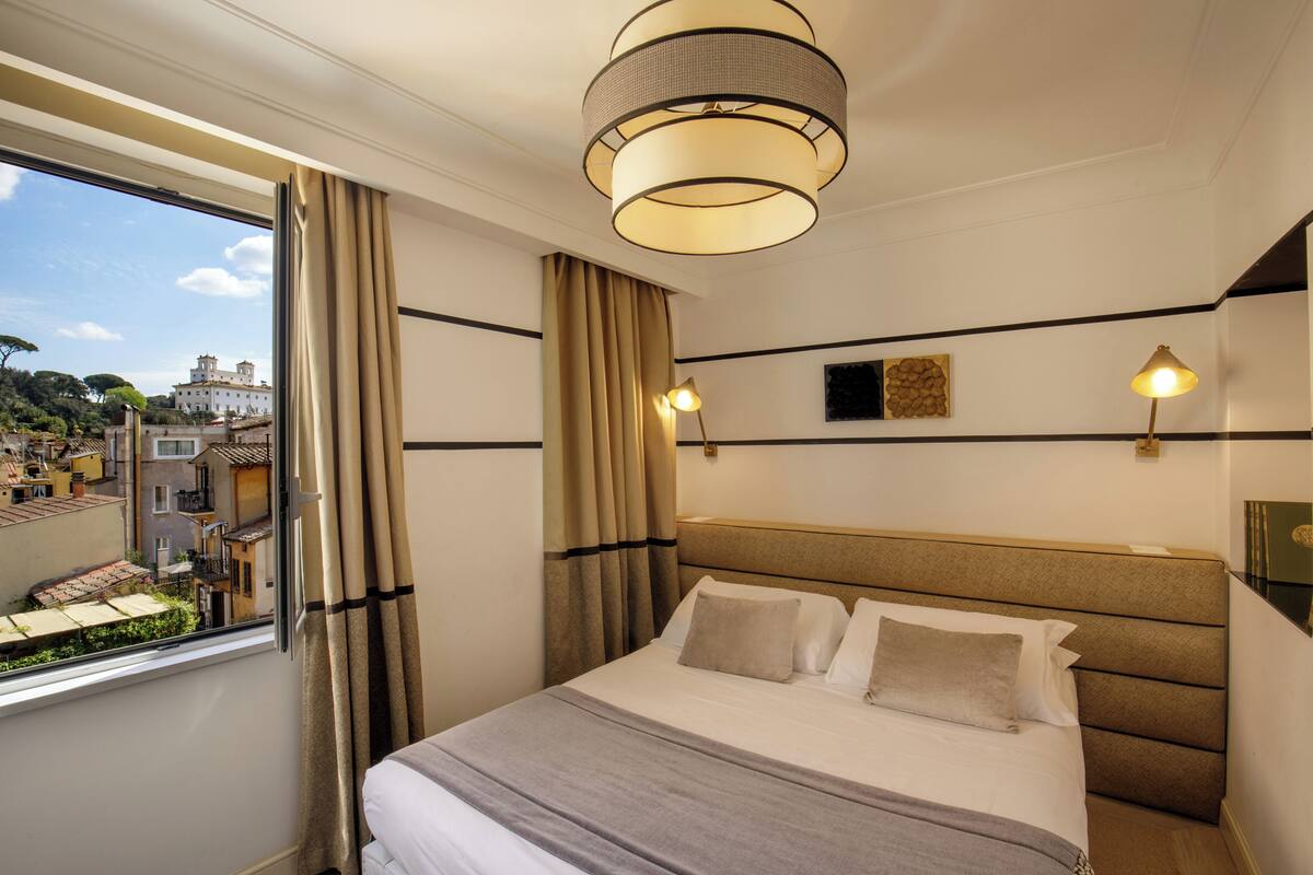 Quarto de hotel com cama, vista da cidade e um candelabro.