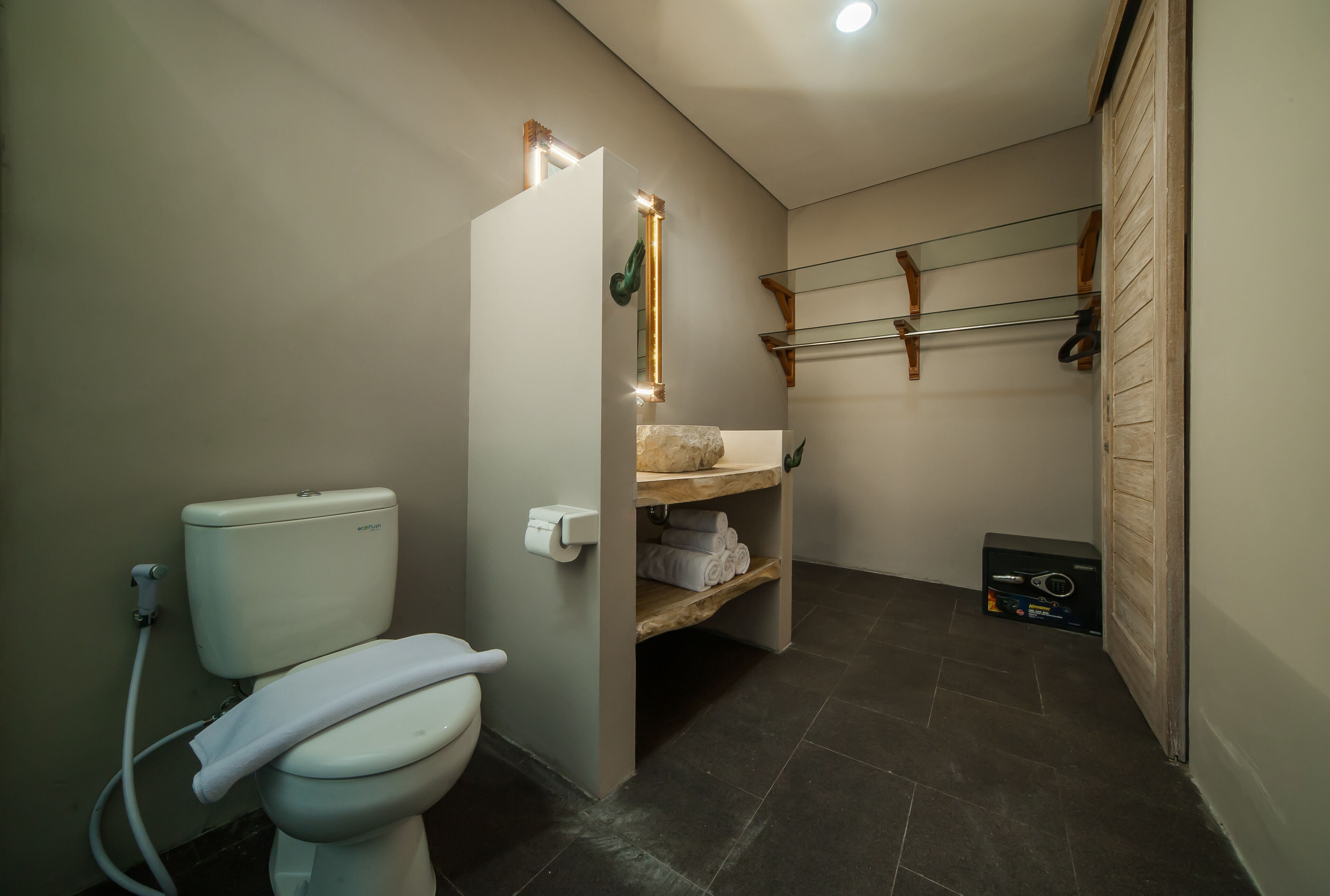 Casa de banho moderna com sanita, uma estante com toalhas e zona de duche.