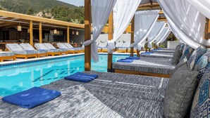 Uma área à beira da piscina com espreguiçadeiras e piscina.