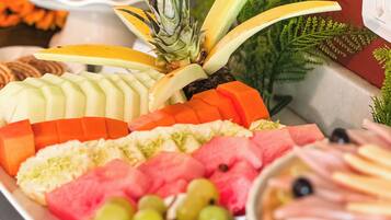 Um buffet com diversas frutas e um bolo.