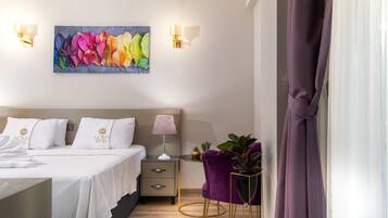 Quarto de hotel com cama, mesas de cabeceira, abajur, cadeira e um quadro na parede.