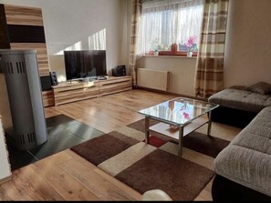 Apartamento, 2 camas queen-size | Sala | Televisor de 30 polegadas com canais digitais, lareira 