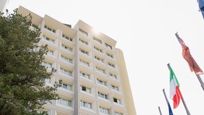 Um hotel de vários andares com design arquitetônico moderno, com uma série de varandas e janelas amplas.