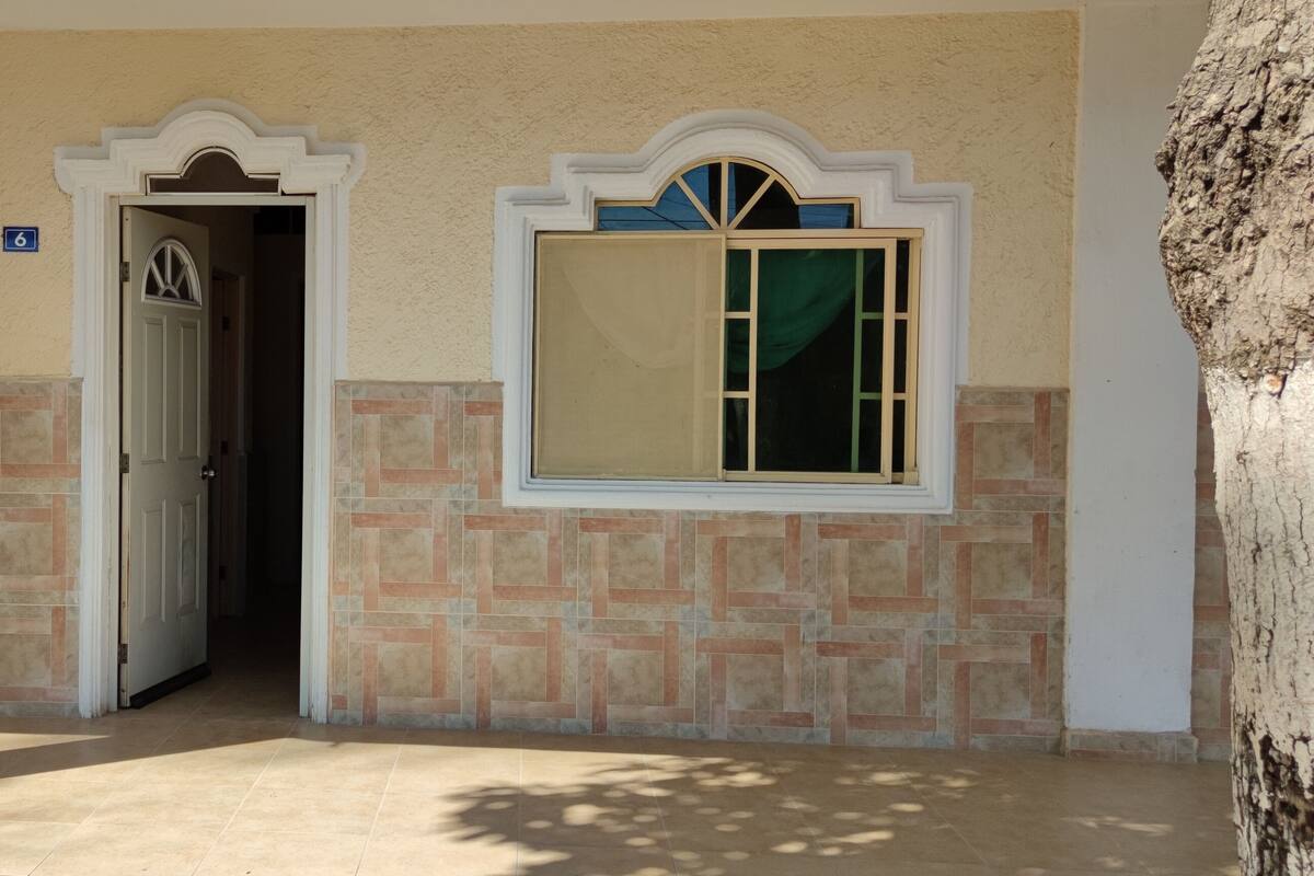 Fachada de edifício com azulejos, uma porta e duas janelas com persianas.