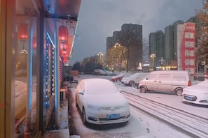 Vista da rua com carros estacionados e edifícios.