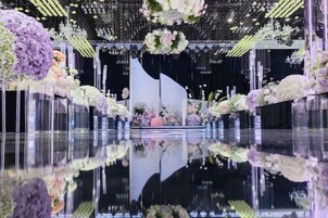 Piso refletorivo com arranjos florais e palco central.