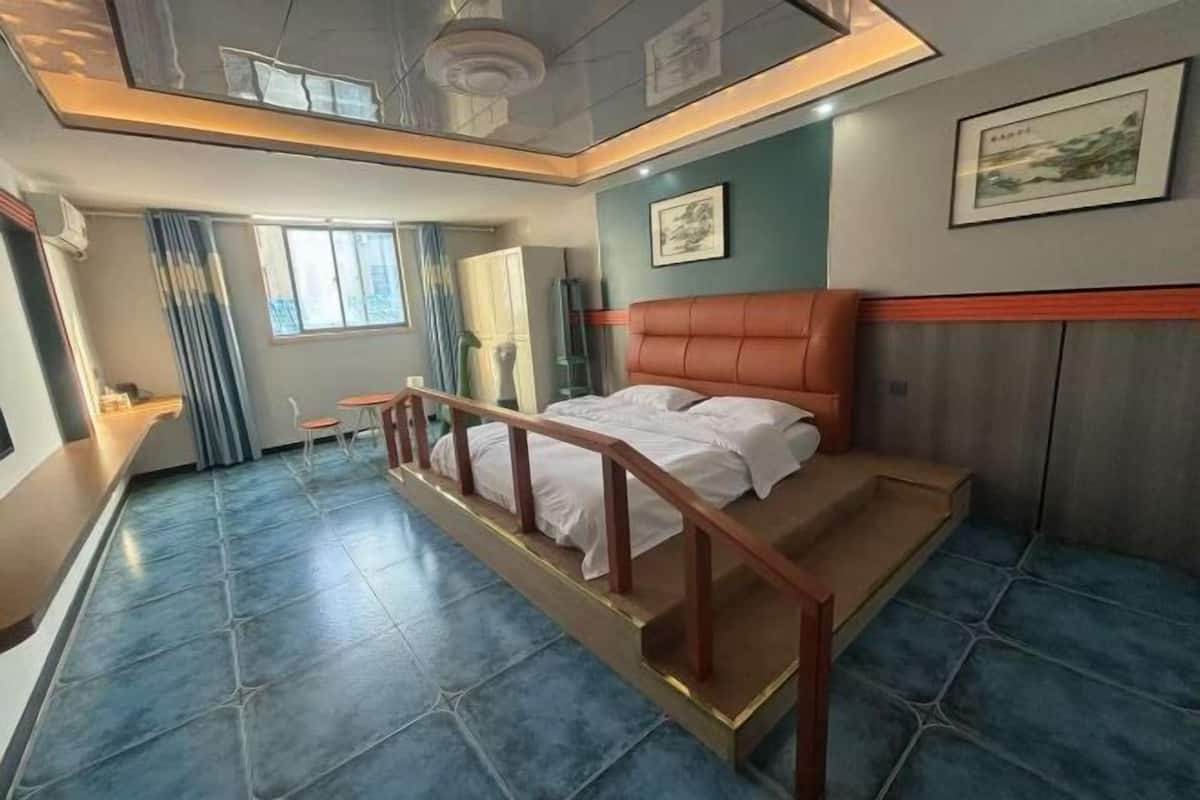 Um quarto com cama, escada, escrivaninha e janela.