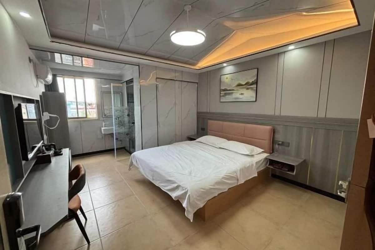 Um quarto com uma cama, uma escrivaninha e uma cadeira.