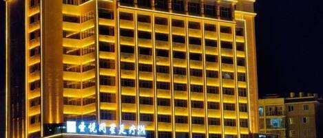 Um hotel com vários andares, sinalização iluminada e design arquitetônico moderno.
