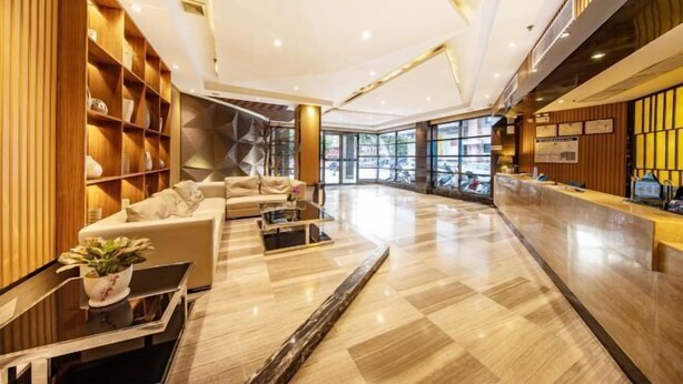 Um lobby moderno com sofá, mesa de centro e estantes de madeira.