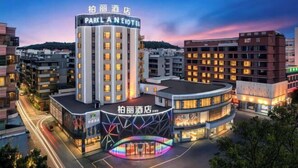 Hotel com vários andares, placa de destaque, átrio circular e área de estacionamento.