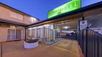 Um motel CBD com placa verde, escritório e altura máxima de 2,4 metros.