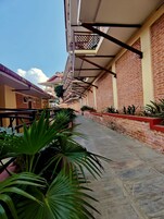 Uma galeria coberta com paredes de tijolo e plantas em vasos.