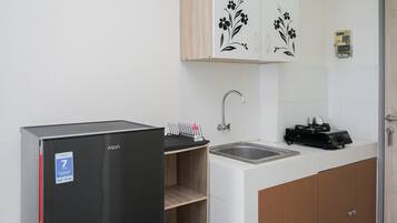 Um frigorífico, uma placa de cozinha, utensílios de cozinha