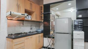 Um frigorífico, uma placa de cozinha, utensílios de cozinha