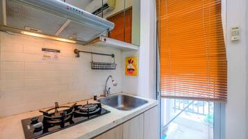 Um frigorífico, uma placa de cozinha, utensílios de cozinha