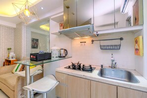 Um frigorífico, uma placa de cozinha, utensílios de cozinha 