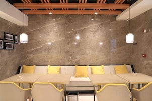 Um interior moderno com parede de mármore, teto de madeira e detalhes em amarelo nos móveis.