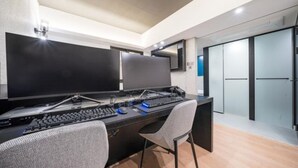 Um espaço de escritório moderno com uma grande escrivaninha, dois monitores, um teclado e uma cadeira.