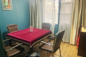 Uma área de refeições com uma mesa vermelha e quatro cadeiras.