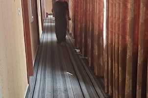 Corredor com piso estampado e cortinas verticais em uma lateral.