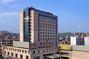 Hotel de vários andares com design moderno, destacando fachada de vidro e telhado plano.