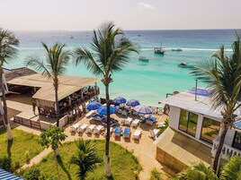 Resort à beira-mar com área de piscina, espreguiçadeiras e guarda-sóis.