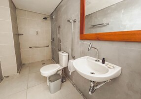 Casa de banho com sanita, bidé, lavatório e espelho.